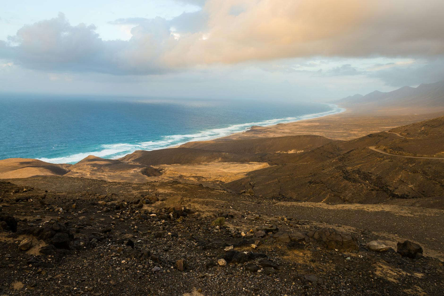 Aerial view of Fuerteventura's rugged volcanic coastline meeting turquoise waters