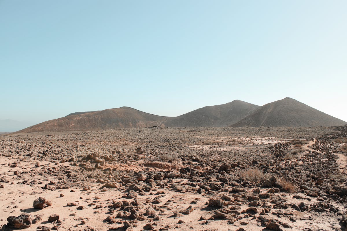 Arid landscape with volcanic mountains and blue sky near La Oliva Fuerteventura