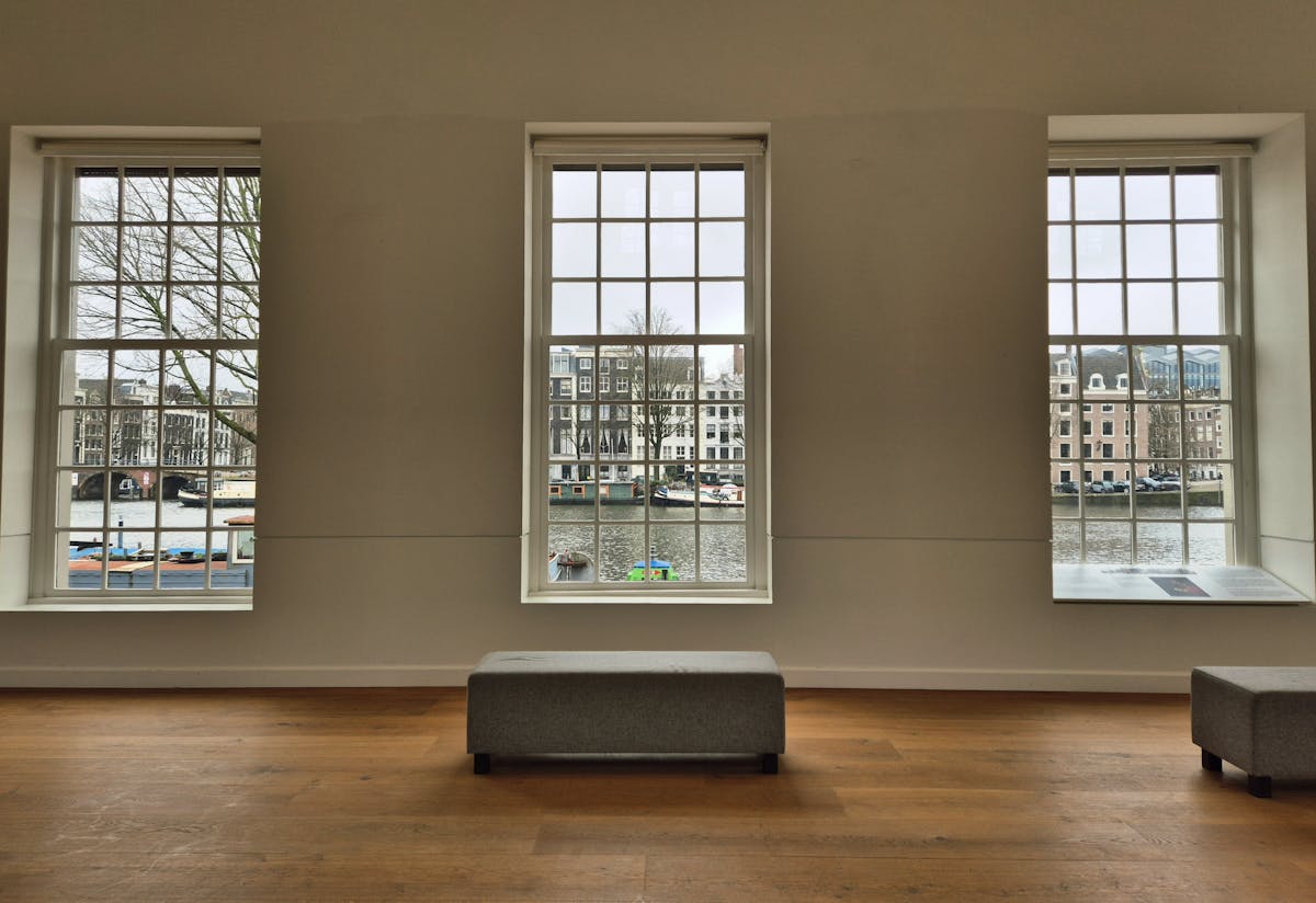 Gallery interior with large windows showcasing a scenic canal view