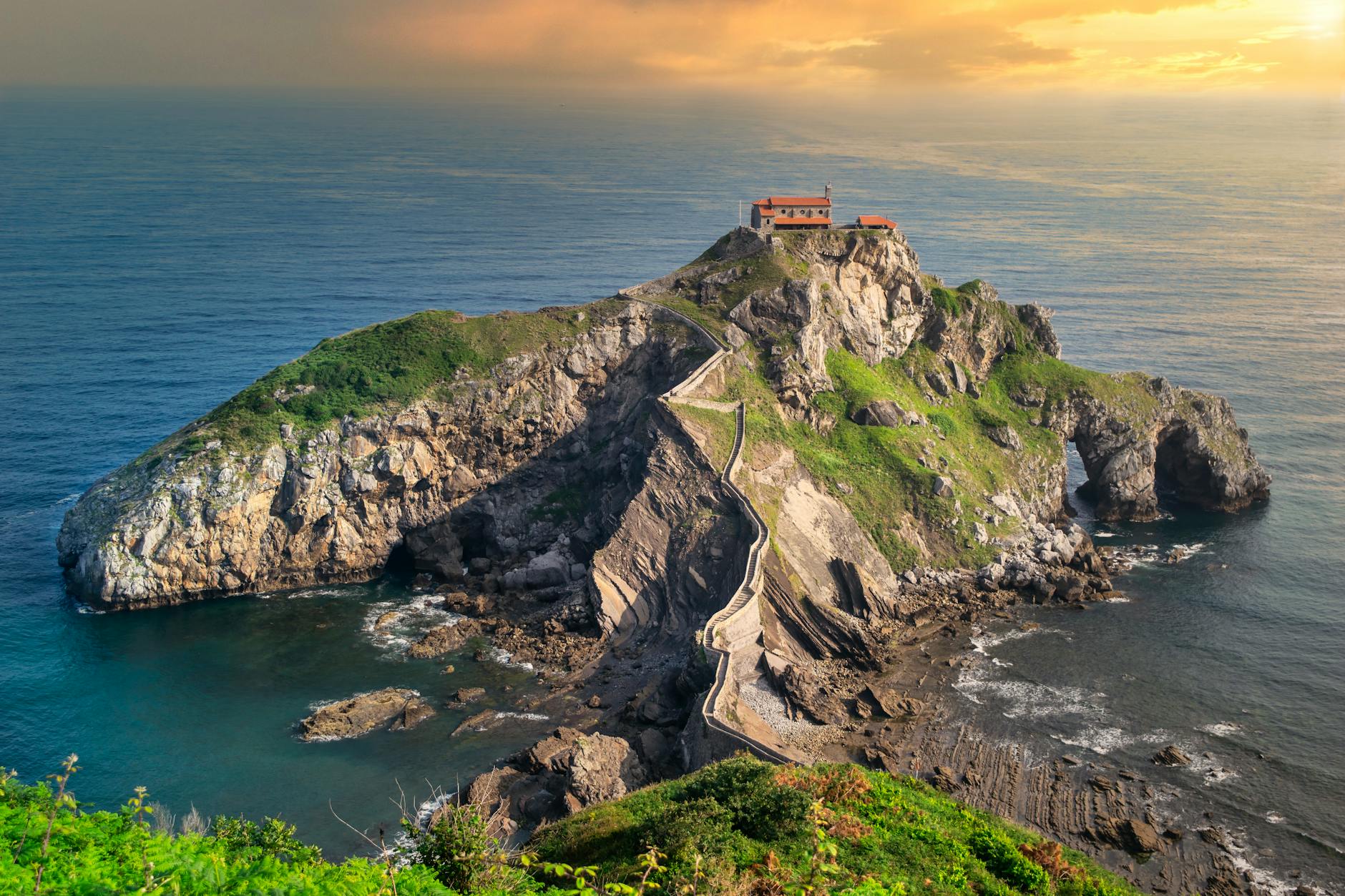 Dramatic aerial view of Gaztelugatxe and the rugged Basque coastline along the Bay of Biscay