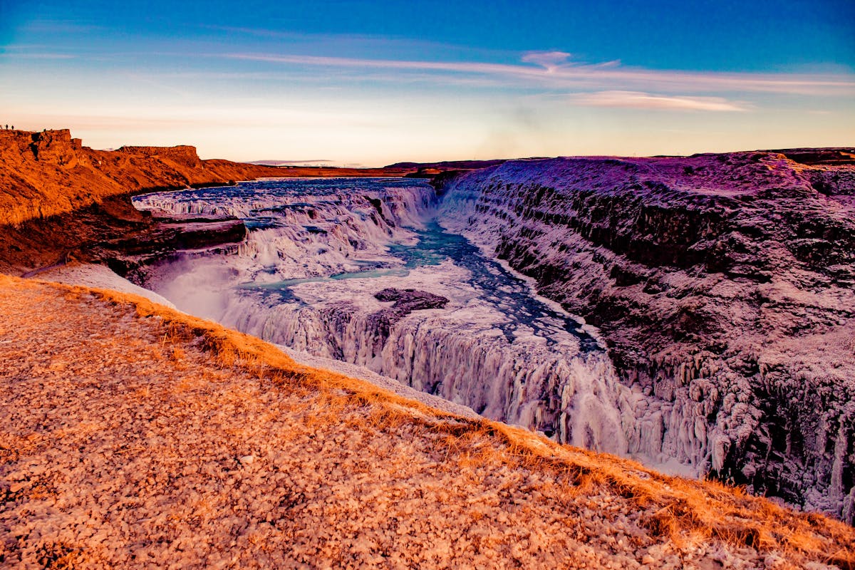 Gullfoss waterfall at sunset with ice and rugged cliffs in Iceland