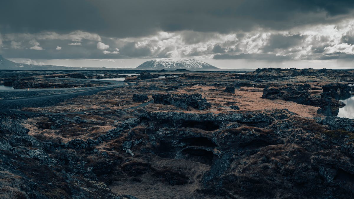 Dramatic Icelandic volcanic terrain with distant mountains under moody skies