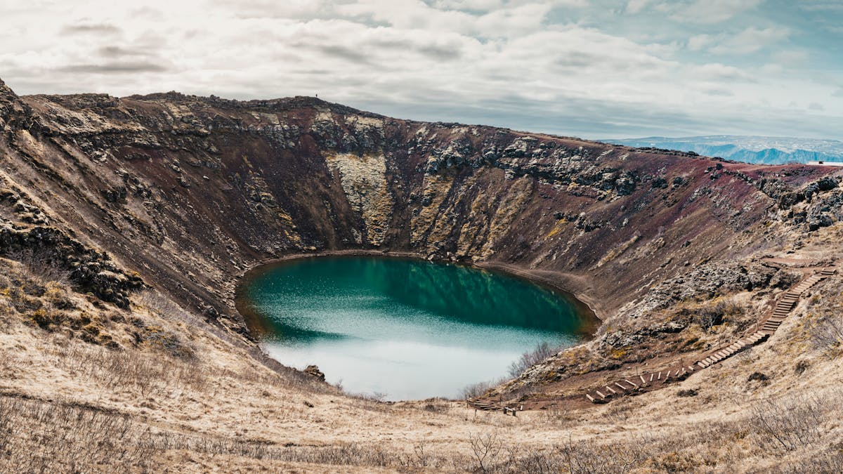Kerid volcanic crater with blue lake surrounded by red rock walls in Iceland