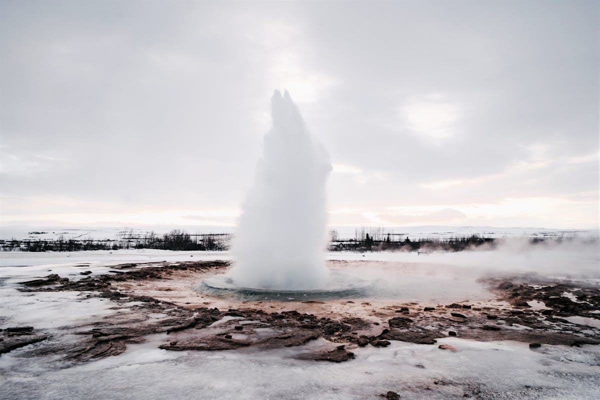 Strokkur geyser erupting with a tall column of water and steam in Iceland