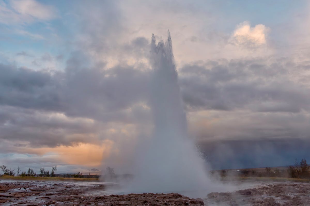 Strokkur geyser erupting against a dramatic evening sky in Iceland