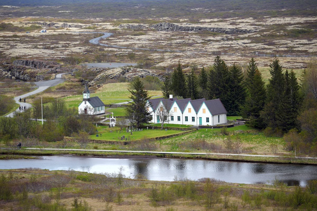 Small white church surrounded by green landscape in Thingvellir National Park Iceland