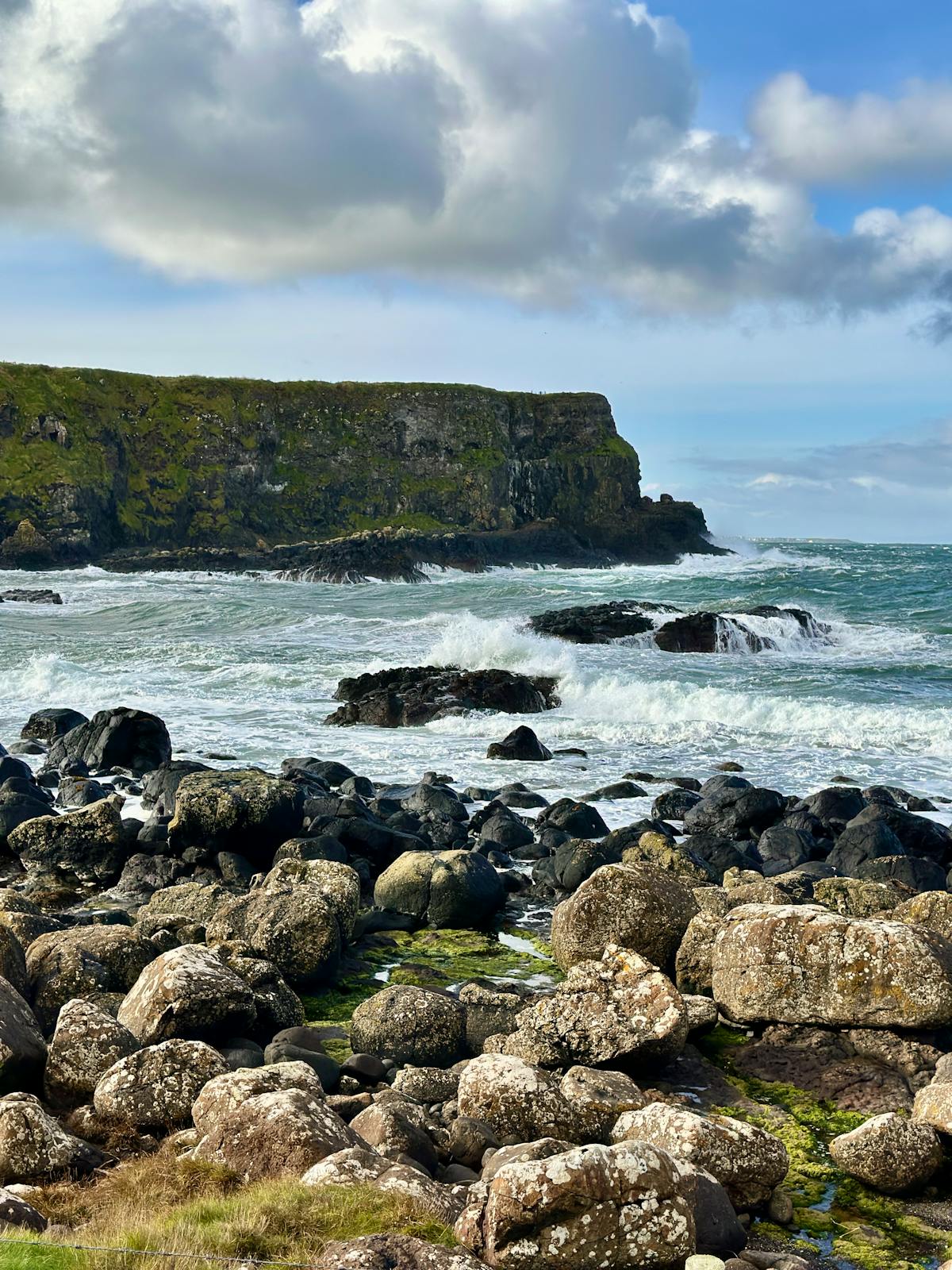 Dramatic rocky coastline with ocean waves near Giants Causeway Northern Ireland