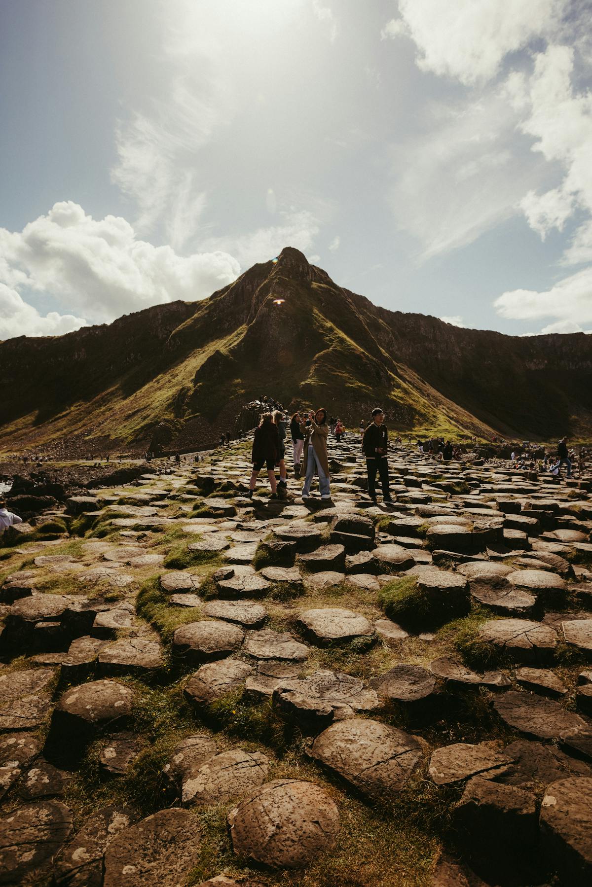 Tourists exploring the interlocking basalt columns at Giants Causeway