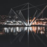 Genoa harbor at night with the illuminated Bigo structure reflected in the water
