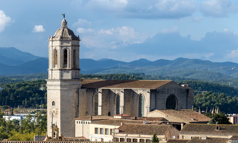 Aerial view of Girona showing the cathedral and old town buildings against mountain backdrop