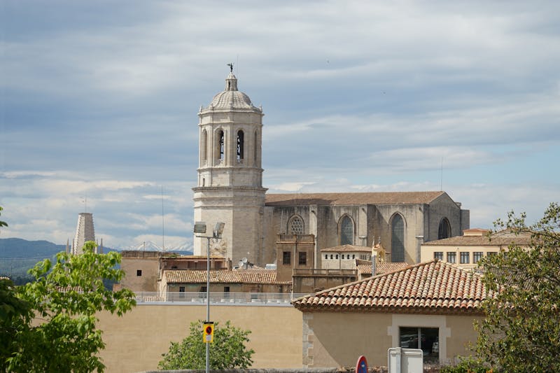 Girona Cathedral rising above the historic city skyline against blue sky
