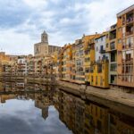Colorful residential buildings reflected in the Onyar River in Girona, Spain
