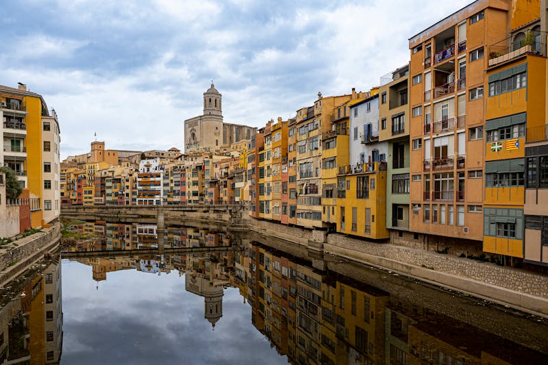 Colorful residential buildings reflected in the Onyar River in Girona, Spain