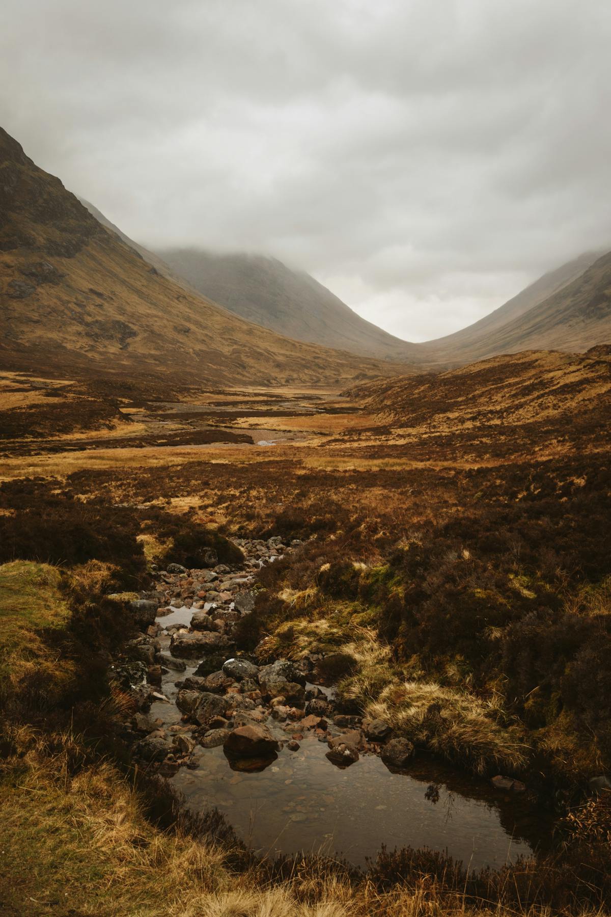 A tranquil stream running through the dramatic Glencoe valley