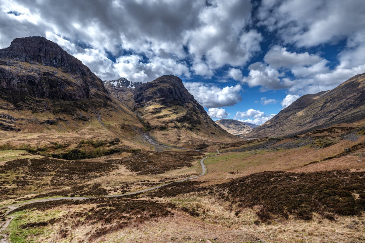 The dramatic Glencoe Valley in Scotland with mountainous terrain and vast open moorland under overcast skies
