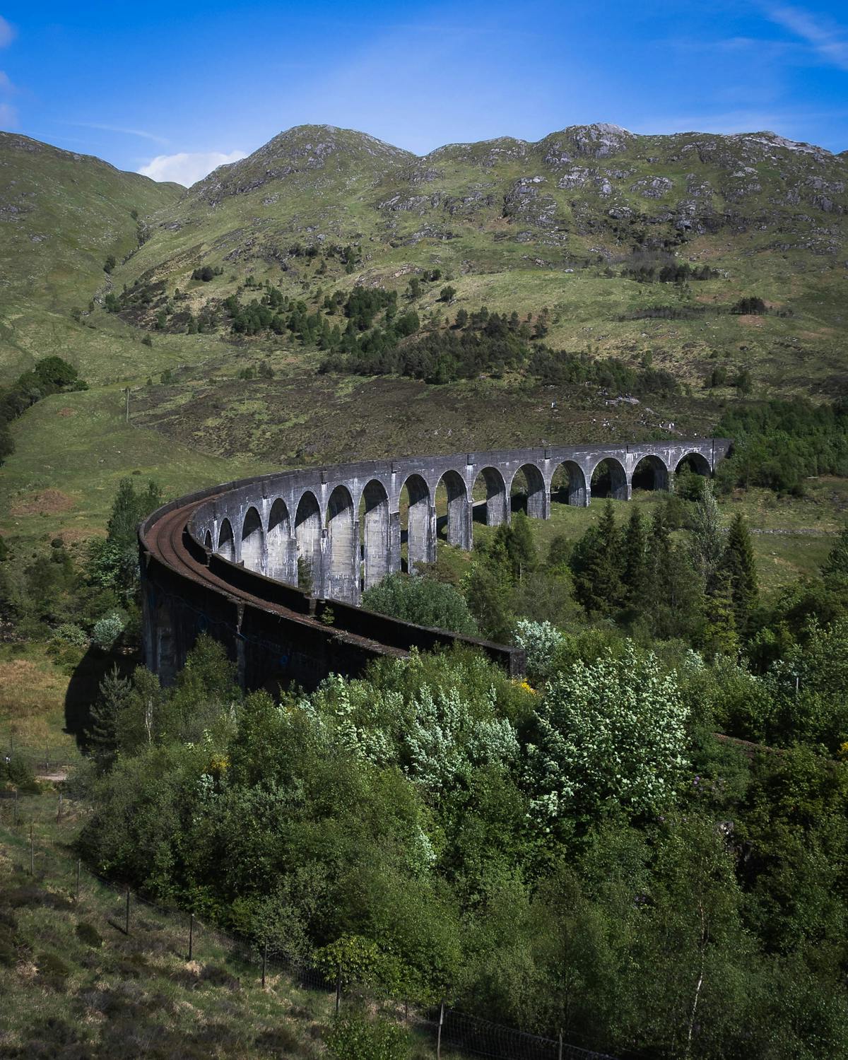 The Glenfinnan Viaduct against the backdrop of Highland mountains