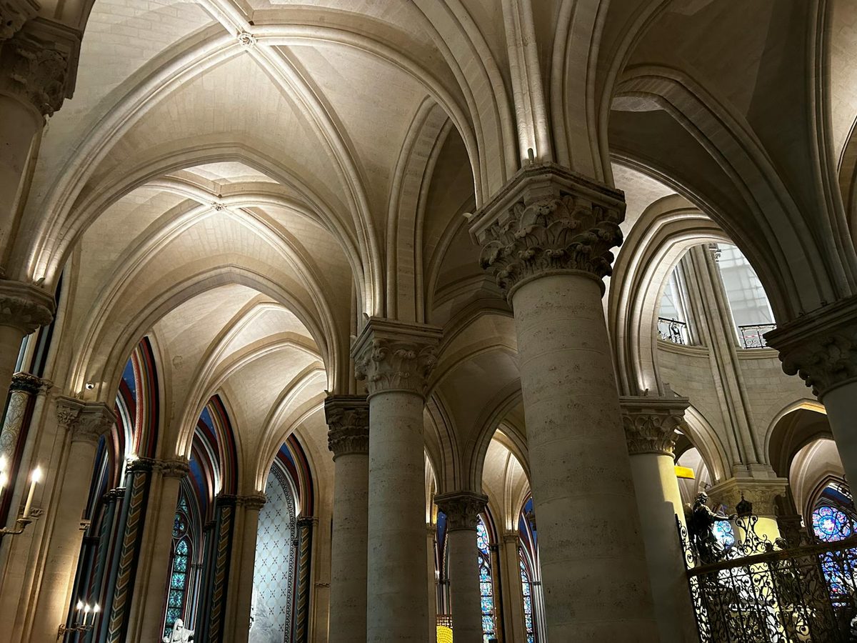Gothic ribbed arches and stained glass inside a Paris cathedral