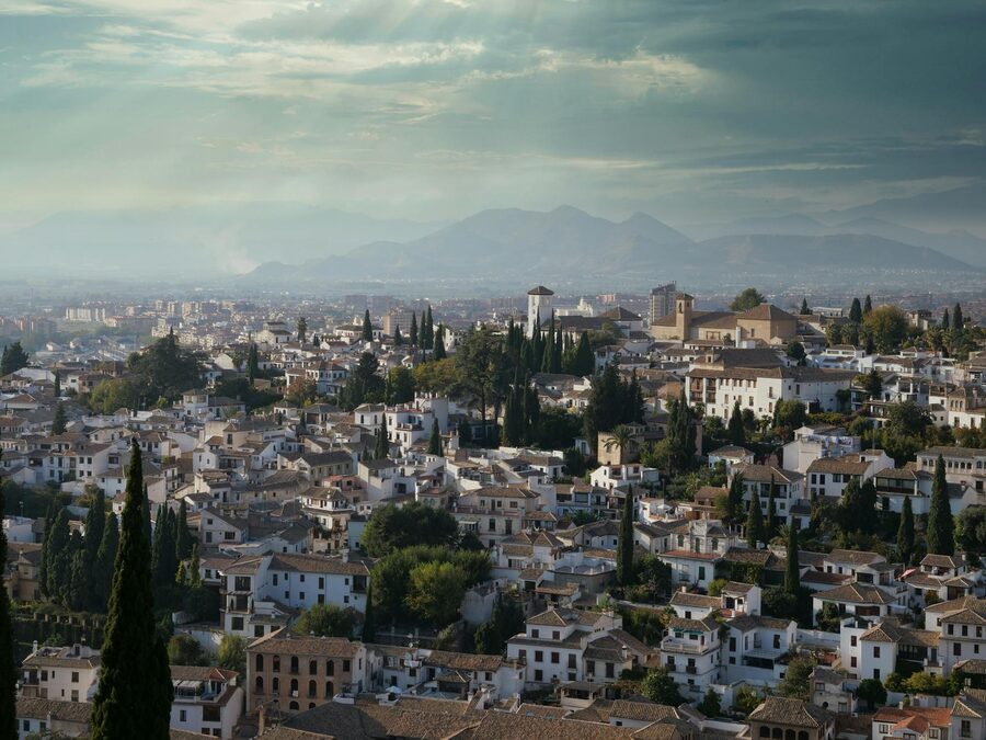 Aerial view of Granada cityscape with historic architecture and mountains in the background