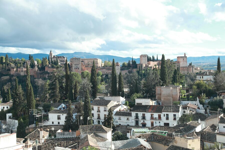 View over Granada rooftops with the Alhambra palace overlooking the historic city