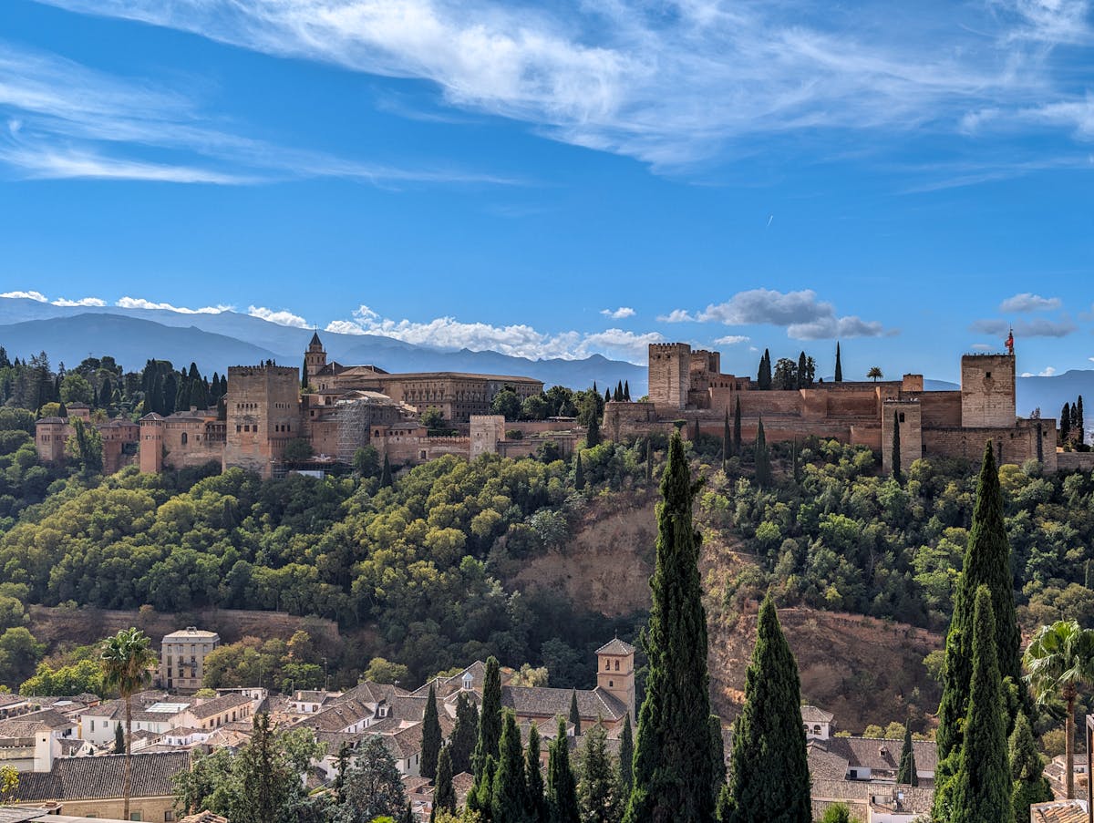 The Alhambra Palace perched on a hilltop overlooking the sprawling city of Granada below