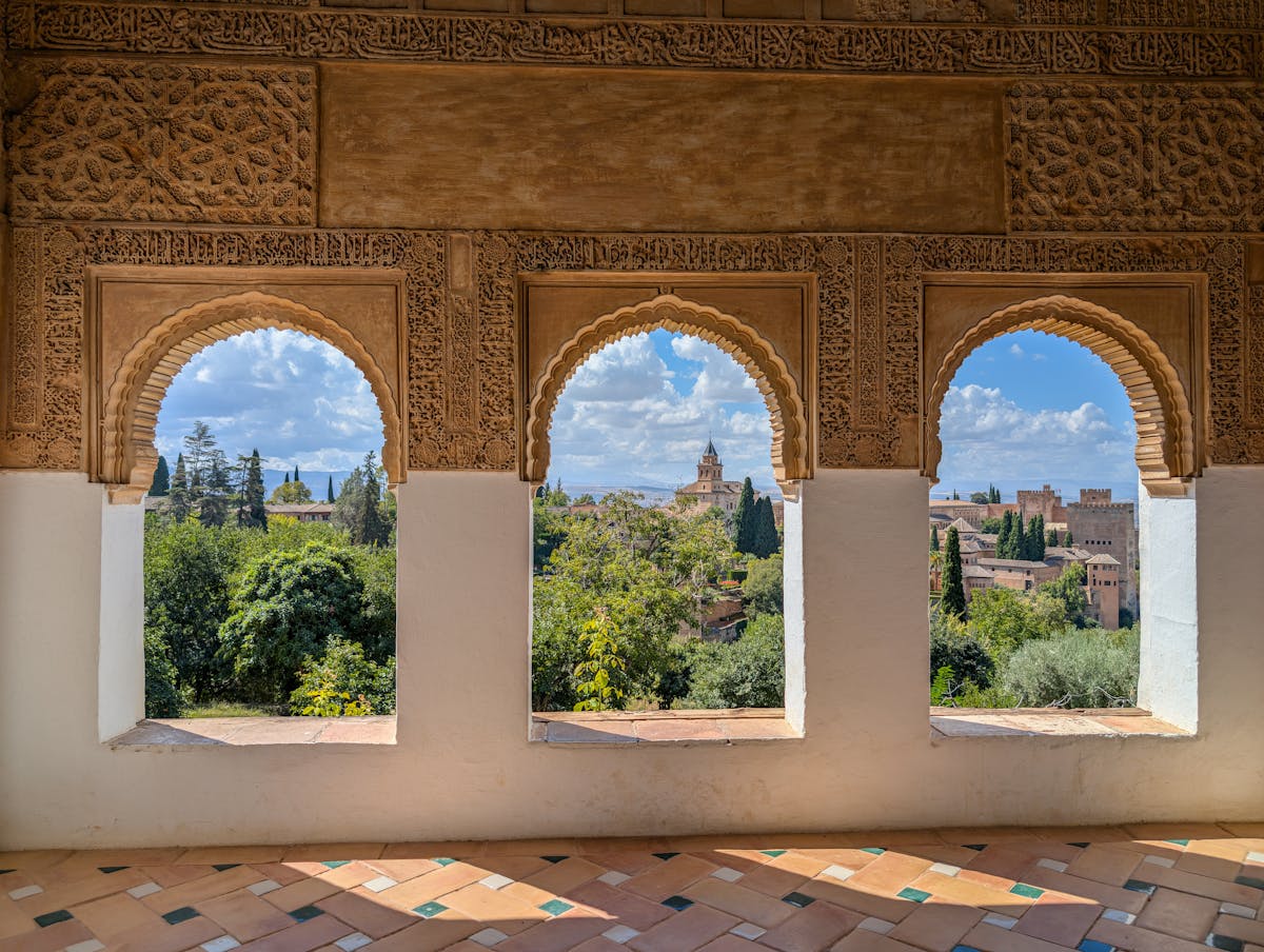 A view of the city of Granada seen through ornate Moorish arches at the Alhambra palace