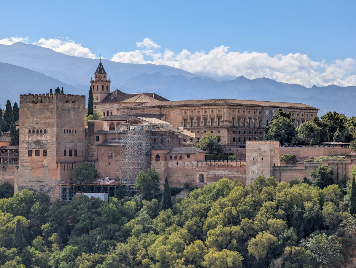 Close-up of the Alhambra fortress walls and towers surrounded by greenery in Granada Spain