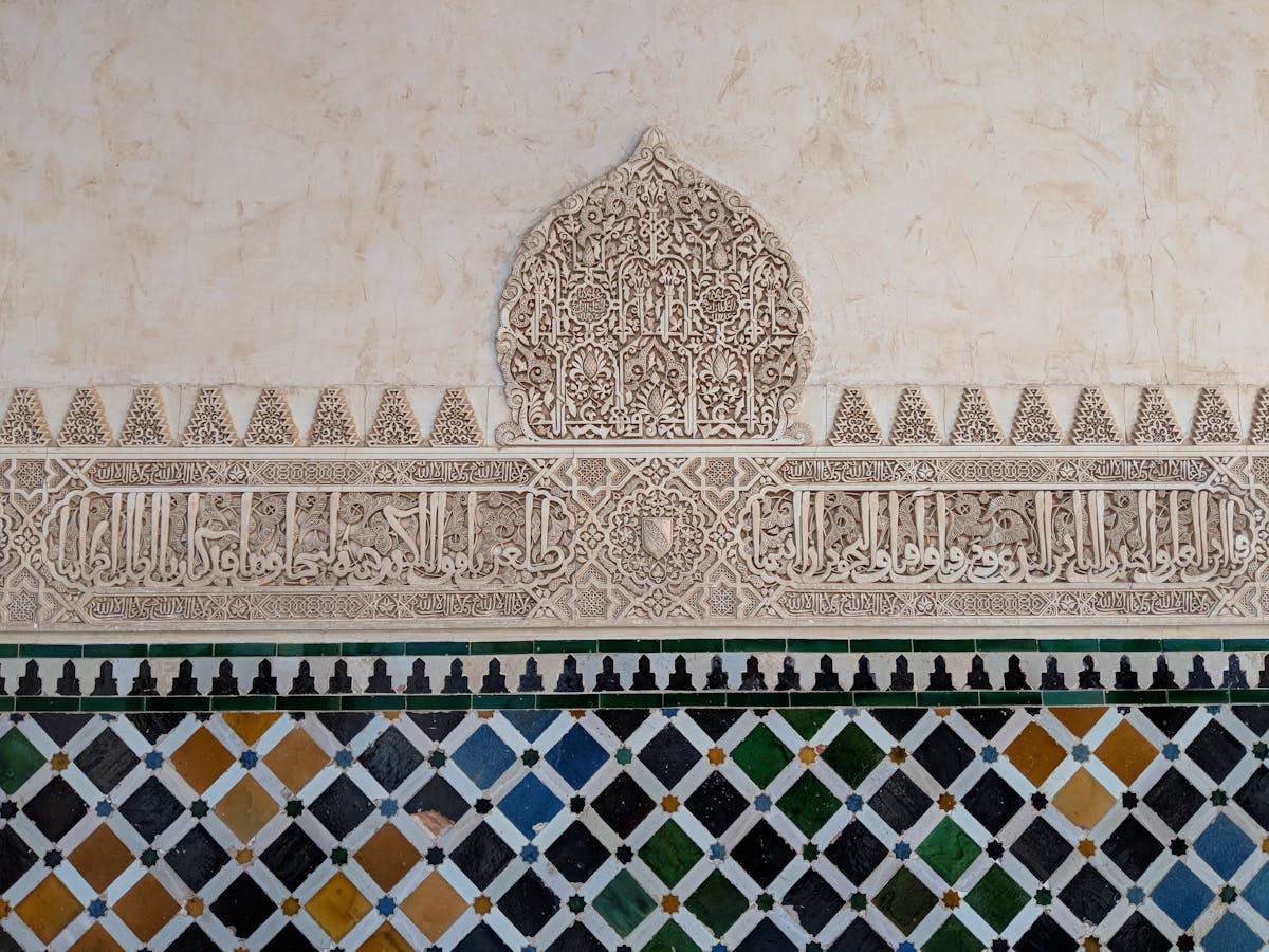 Detailed geometric Islamic wall carving and ornamentation inside the Alhambra palace in Granada Spain