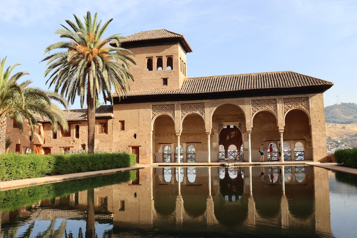 The Alhambra palace reflecting pool with palm trees in Granada Spain