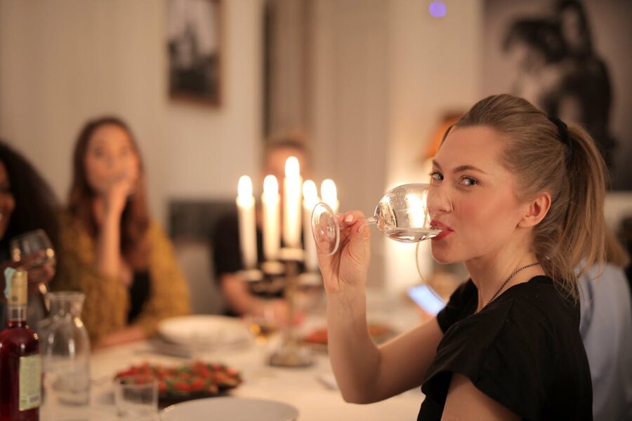Group of friends enjoying wine and conversation at a cozy candlelit dinner