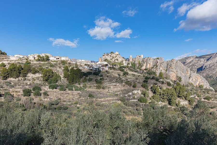 A narrow cobbled street in Guadalest village lined with traditional stone buildings and tourist shops