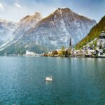 Swan on lake with Hallstatt village and mountains in background Austria