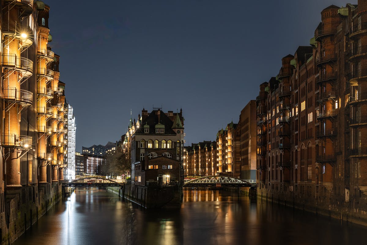 Illuminated red brick warehouses and canals in Hamburg Speicherstadt district at night