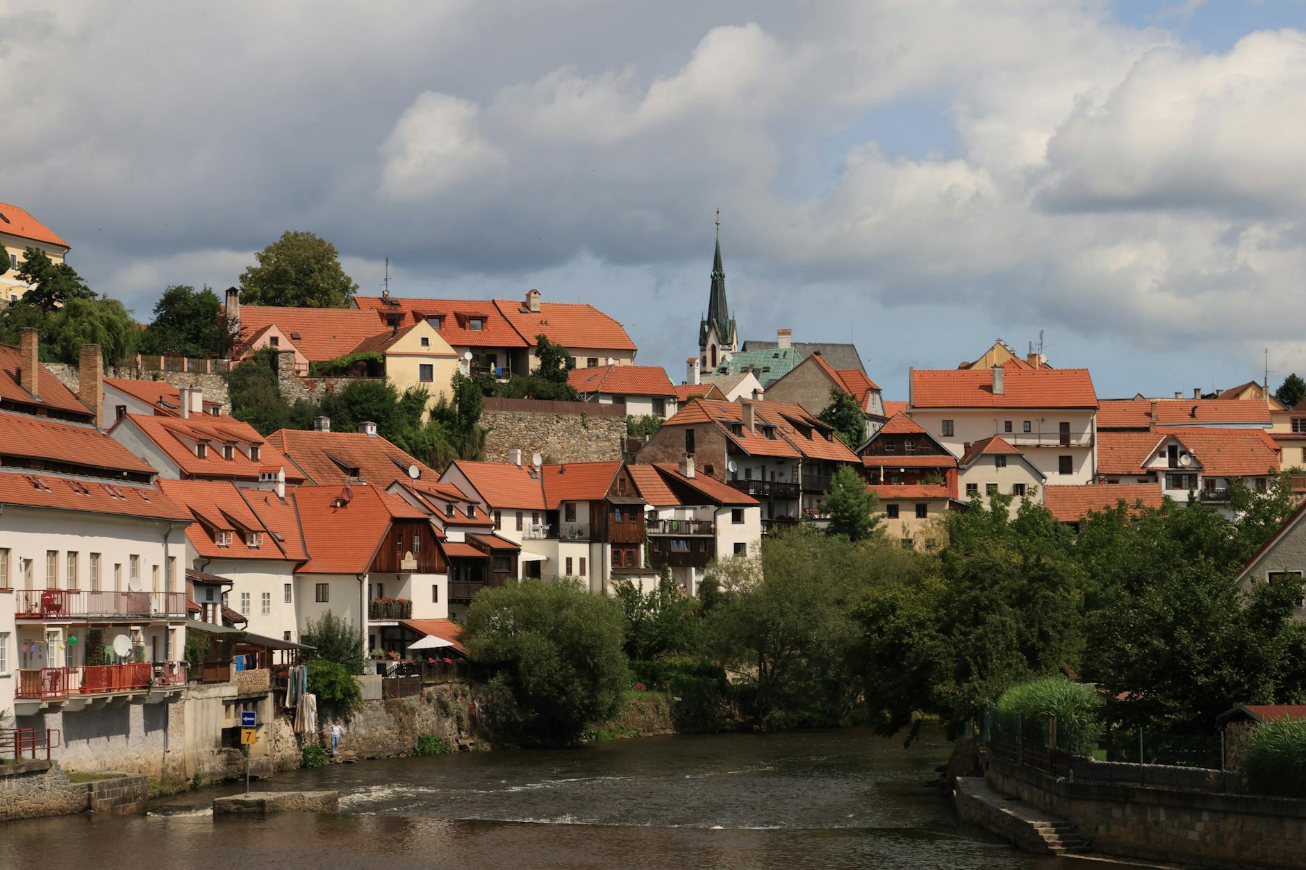 European village with red-tiled roofs along a river