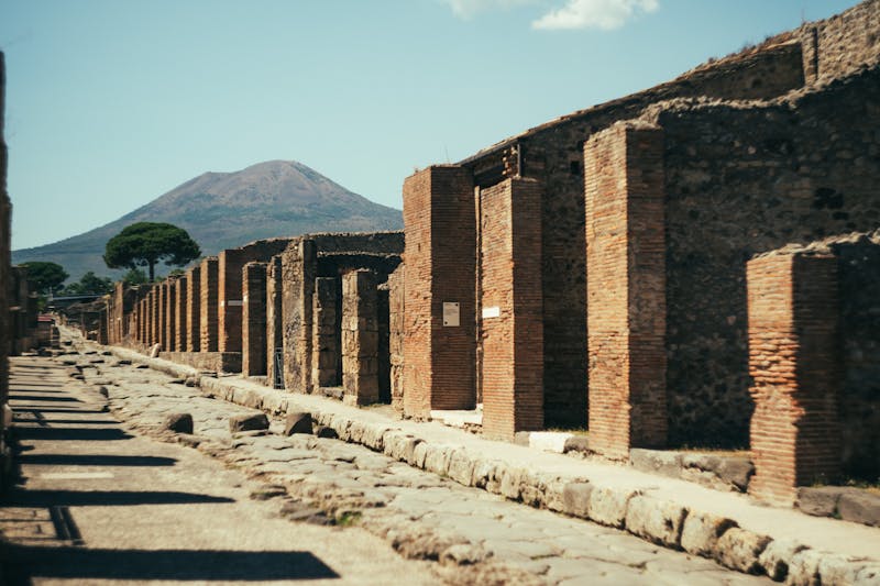 View of ancient ruins in Pompeii with Mount Vesuvius looming in the background