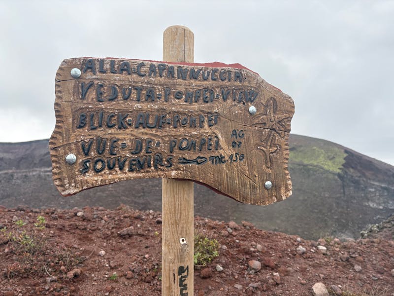 Wooden sign post overlooking Pompeii from the Mount Vesuvius hiking trail