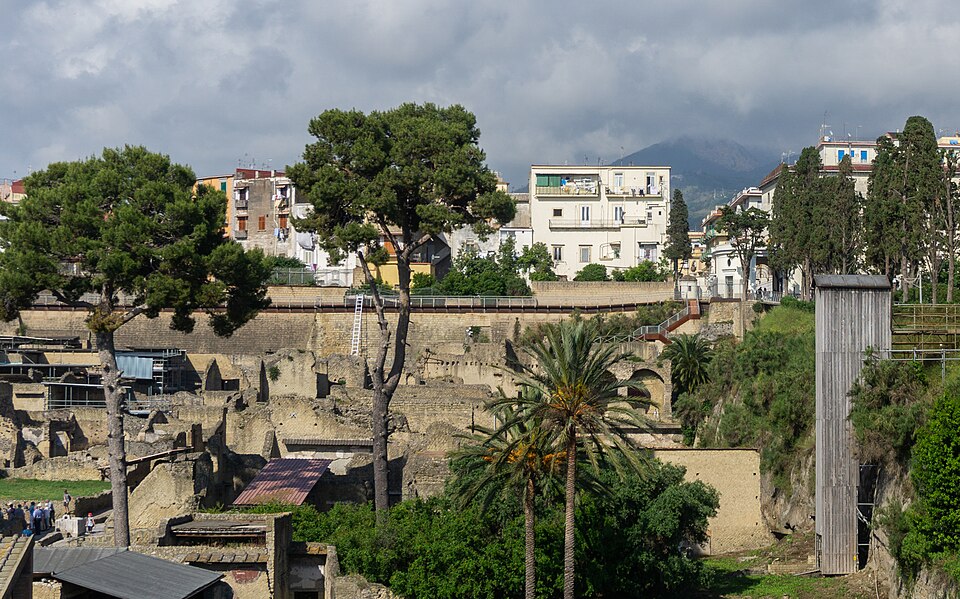 Panoramic view of the excavated ruins of Herculaneum with the modern town of Ercolano above and Mount Vesuvius in the background