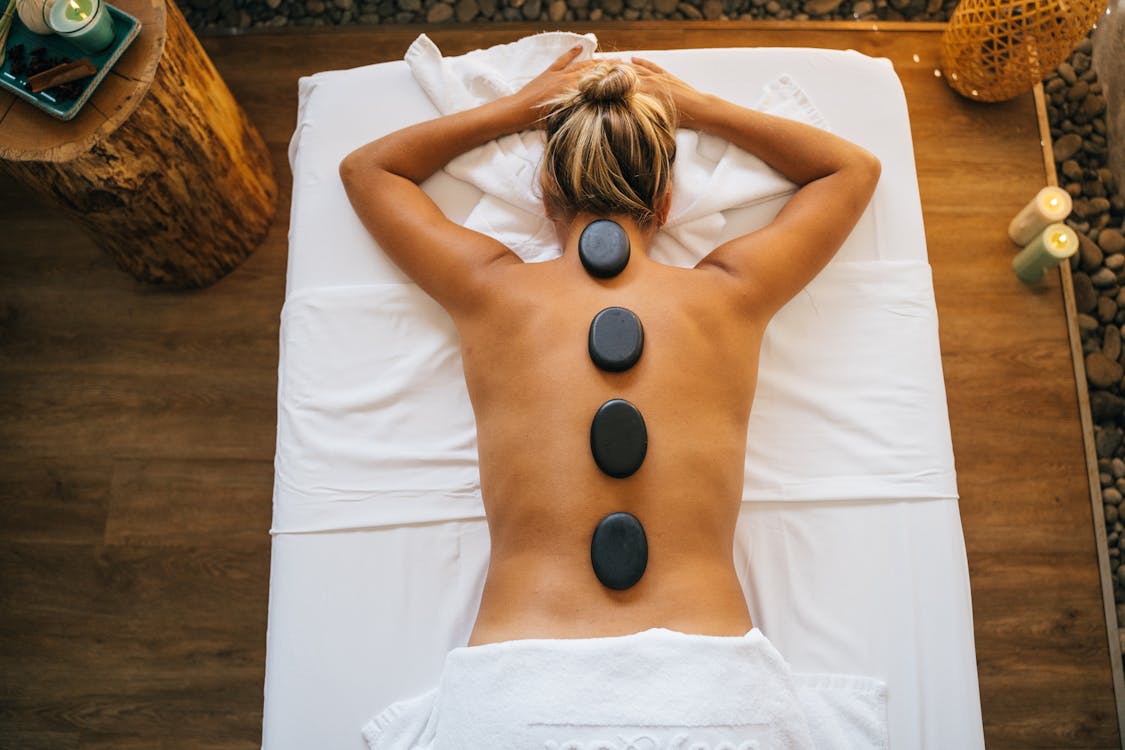 A woman enjoying a hot stone massage treatment at a spa