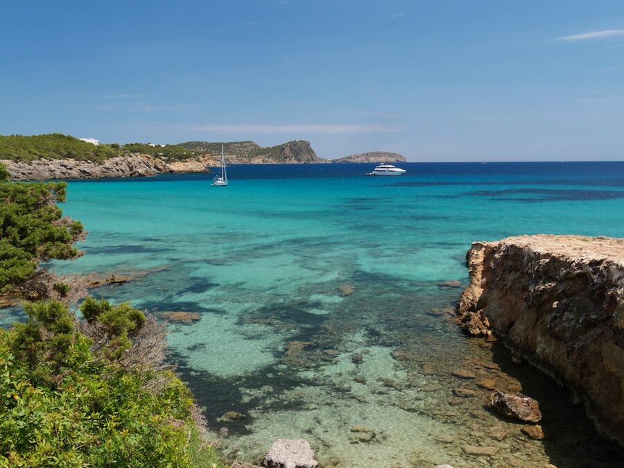 Turquoise waters and stunning coastline of Cala Nova in Ibiza Spain