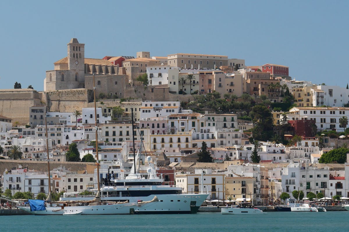 View of Ibiza Dalt Vila historic old town rising above a harbor full of yachts