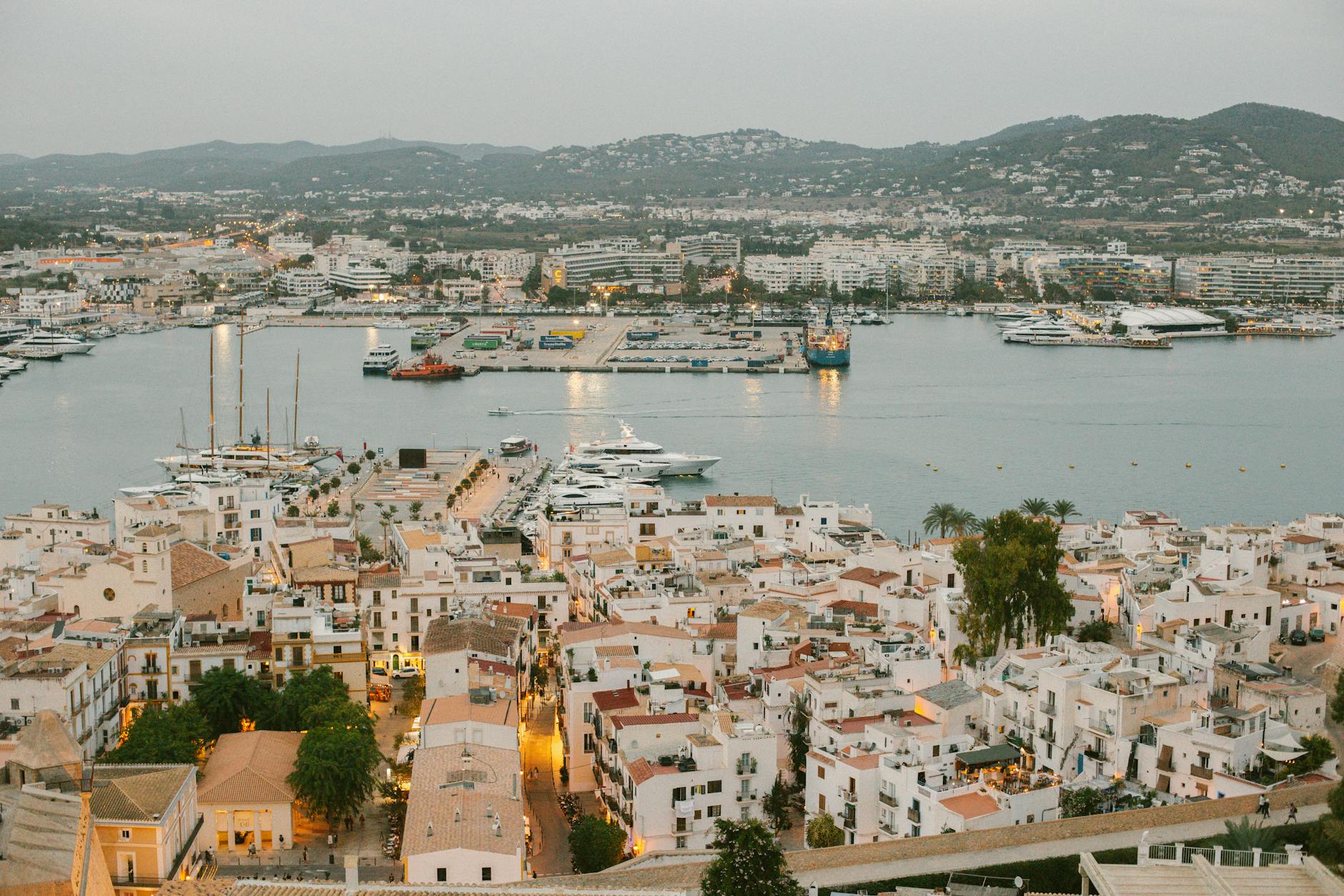 Aerial panoramic view of Ibiza port with yachts and city lights