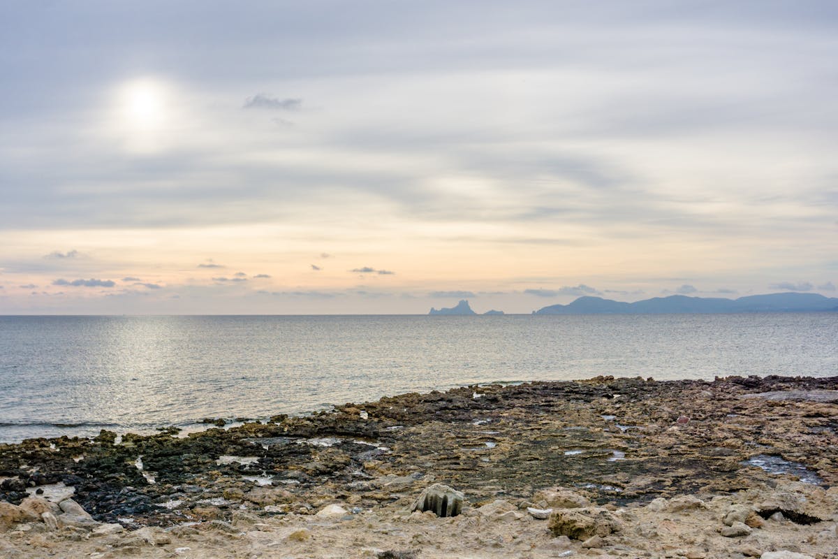 Peaceful sunset light over a rocky seashore in Ibiza, Spain