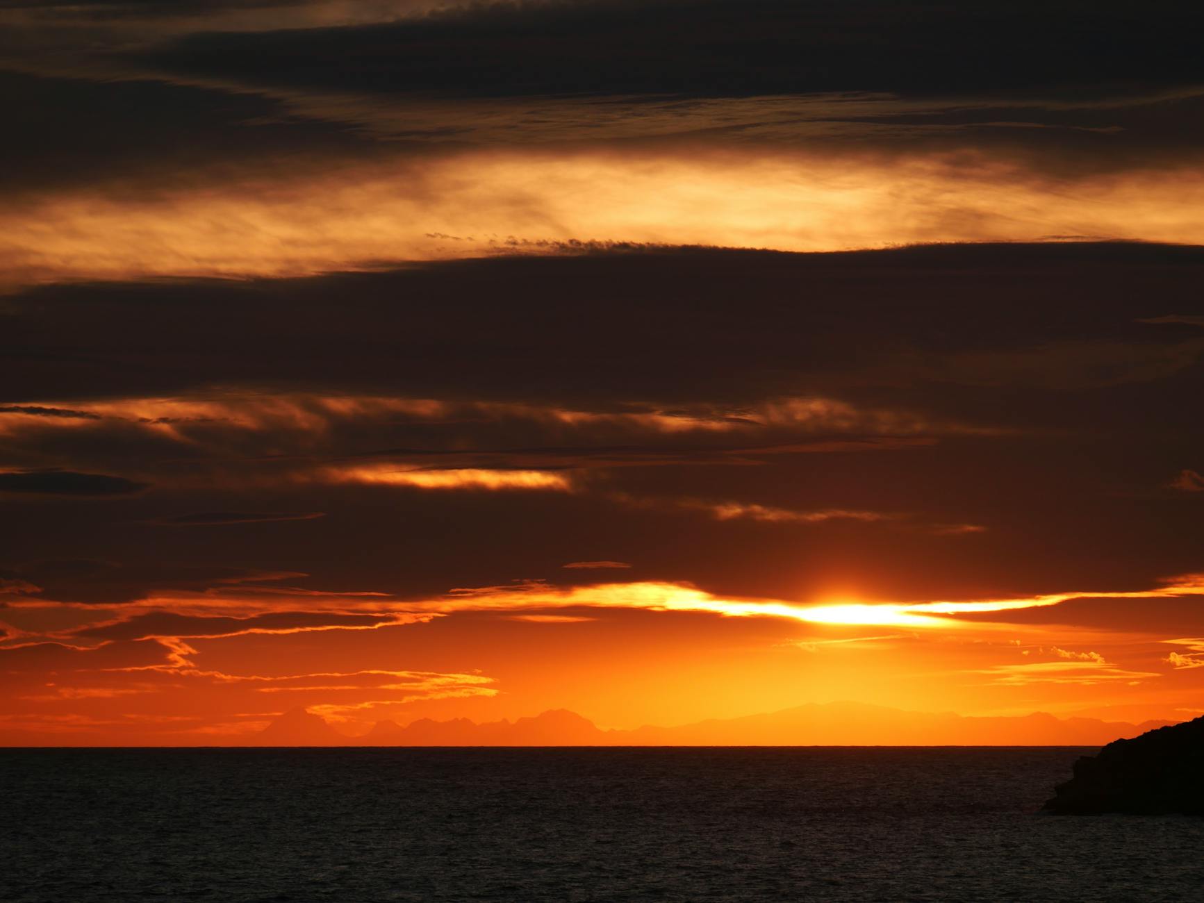 Vivid sunset colors reflected on the calm Mediterranean sea near Ibiza