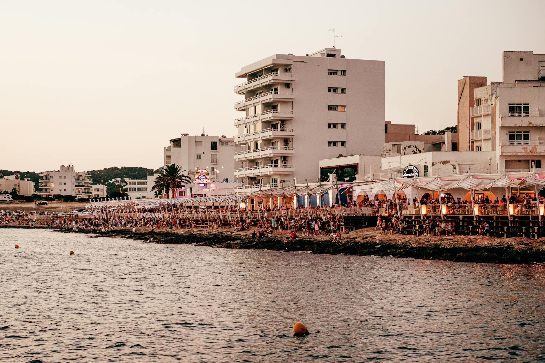 Ibiza waterfront with boats and coastal nightlife at sunset