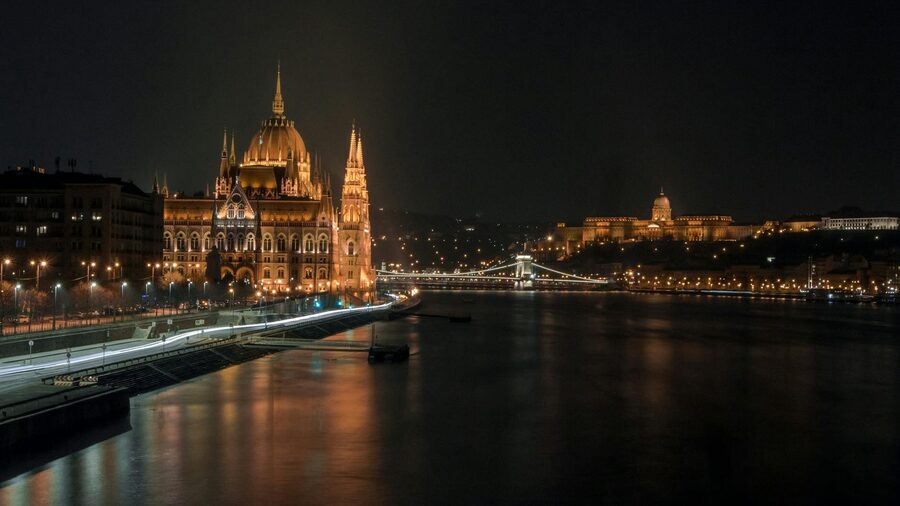 Illuminated Hungarian Parliament with Chain Bridge over the Danube River at night in Budapest