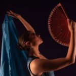 Flamenco dancer mid-performance with flowing red dress in a small Malaga tablao
