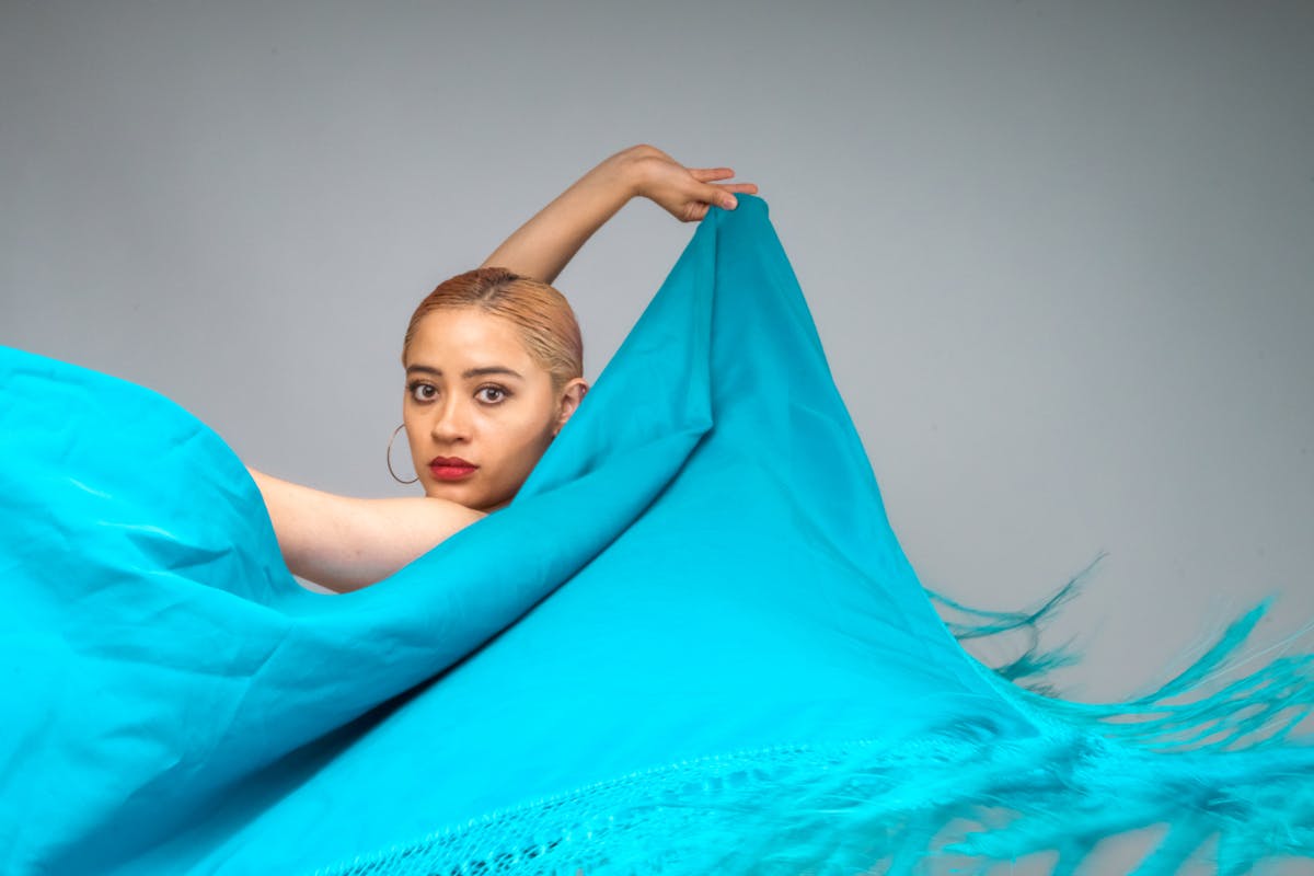 Flamenco dancer performing on a small lit stage at a traditional tablao