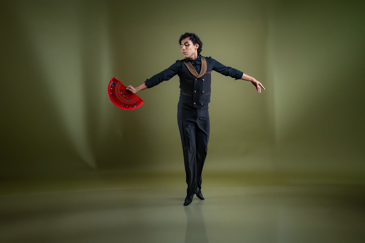 Two flamenco dancers performing a duet on a dimly lit stage