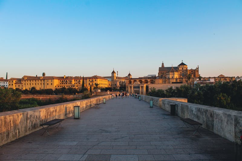 The Roman Bridge crossing the Guadalquivir River with the Mosque-Cathedral of Cordoba in the background at sunset