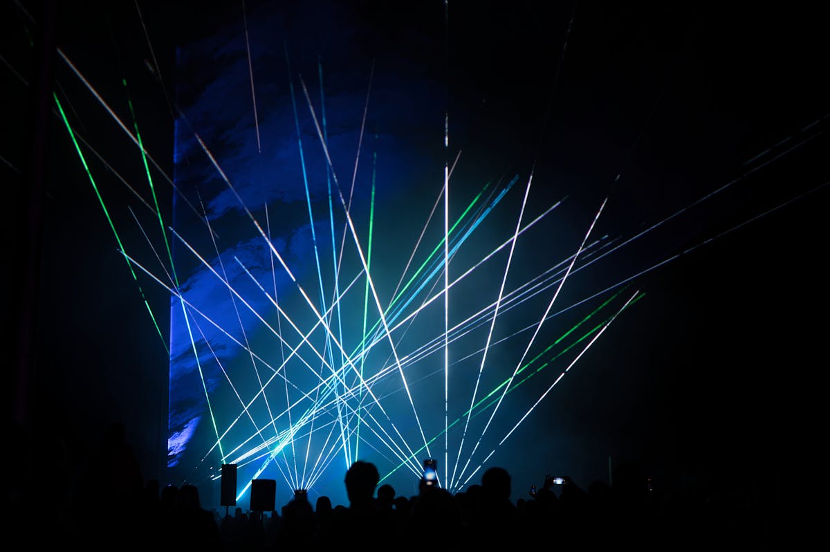 Vibrant laser show with green and blue lights captivating an audience
