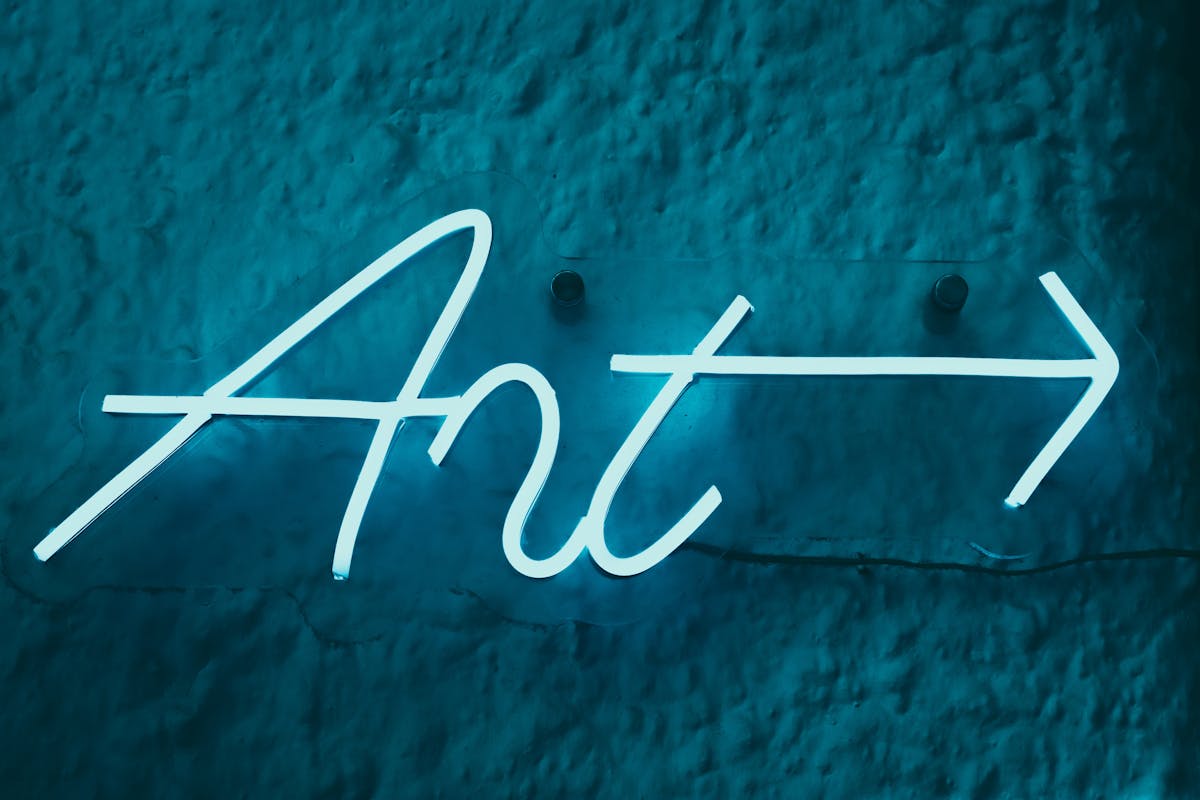 Neon art sign with arrow on a textured wall with vibrant electric blue glow